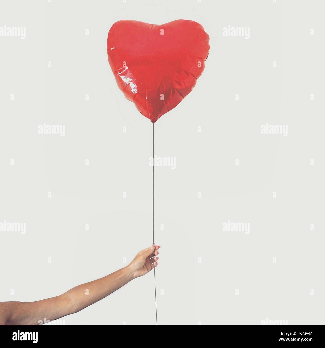 Hand holding heart shape balloon hi-res stock photography and images ...