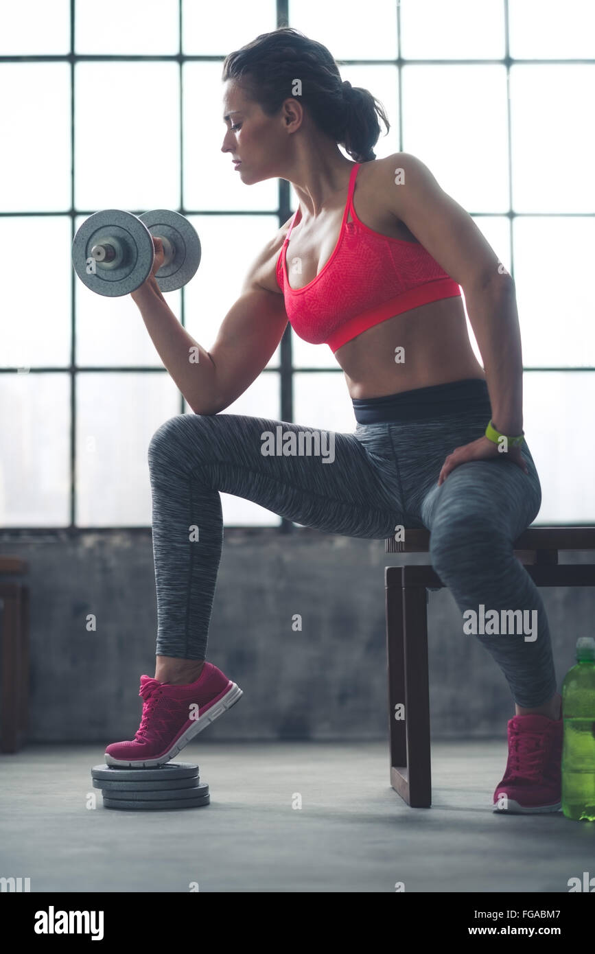 Body and mind workout in loft fitness studio. Fitness woman lifting ...