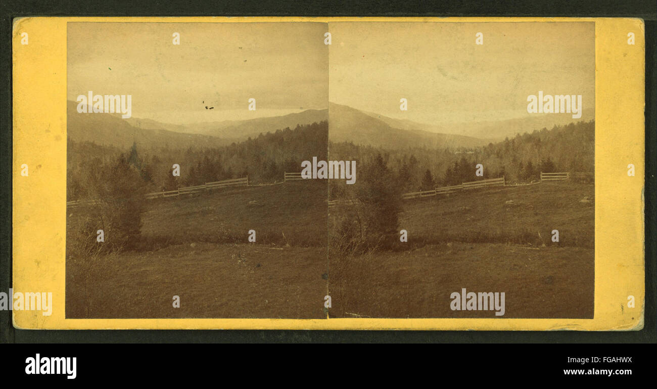A photograph of a mountain landscape, with fences in the foreground ...