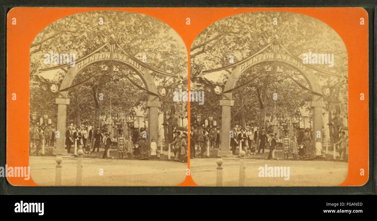 Photograph showing a crowd gathered under a decorated arch with the ...