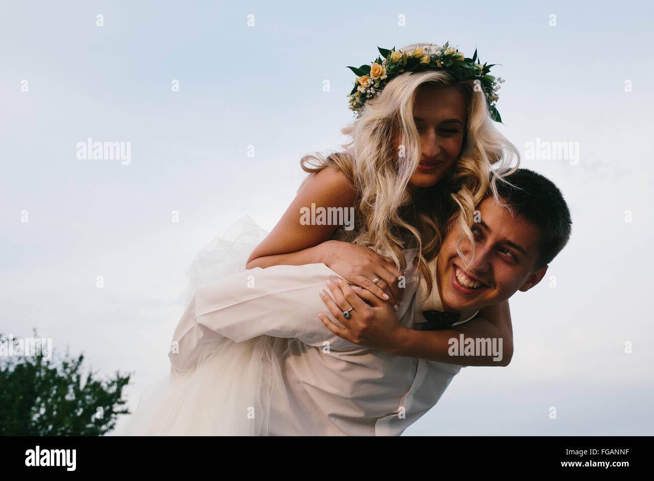 groom carries bride on his back outdoors Stock Photo - Alamy
