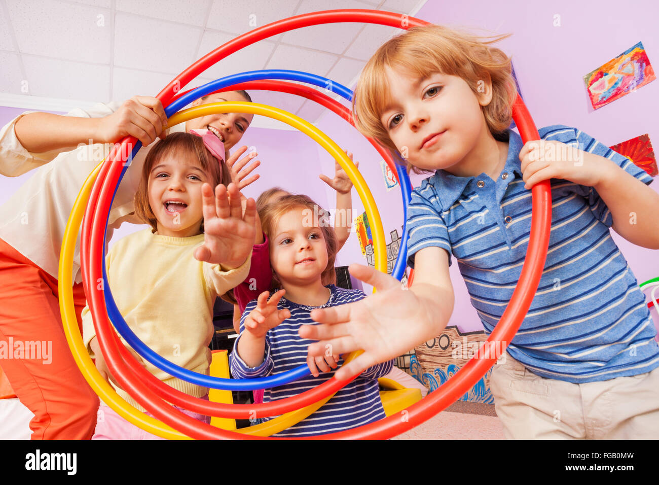 Fun in active class lesson boy and girls with hoop Stock Photo - Alamy