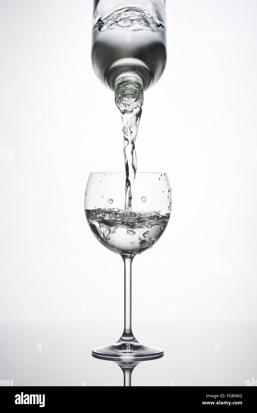bottle pouring water in glass with bubbles on white background Stock ...