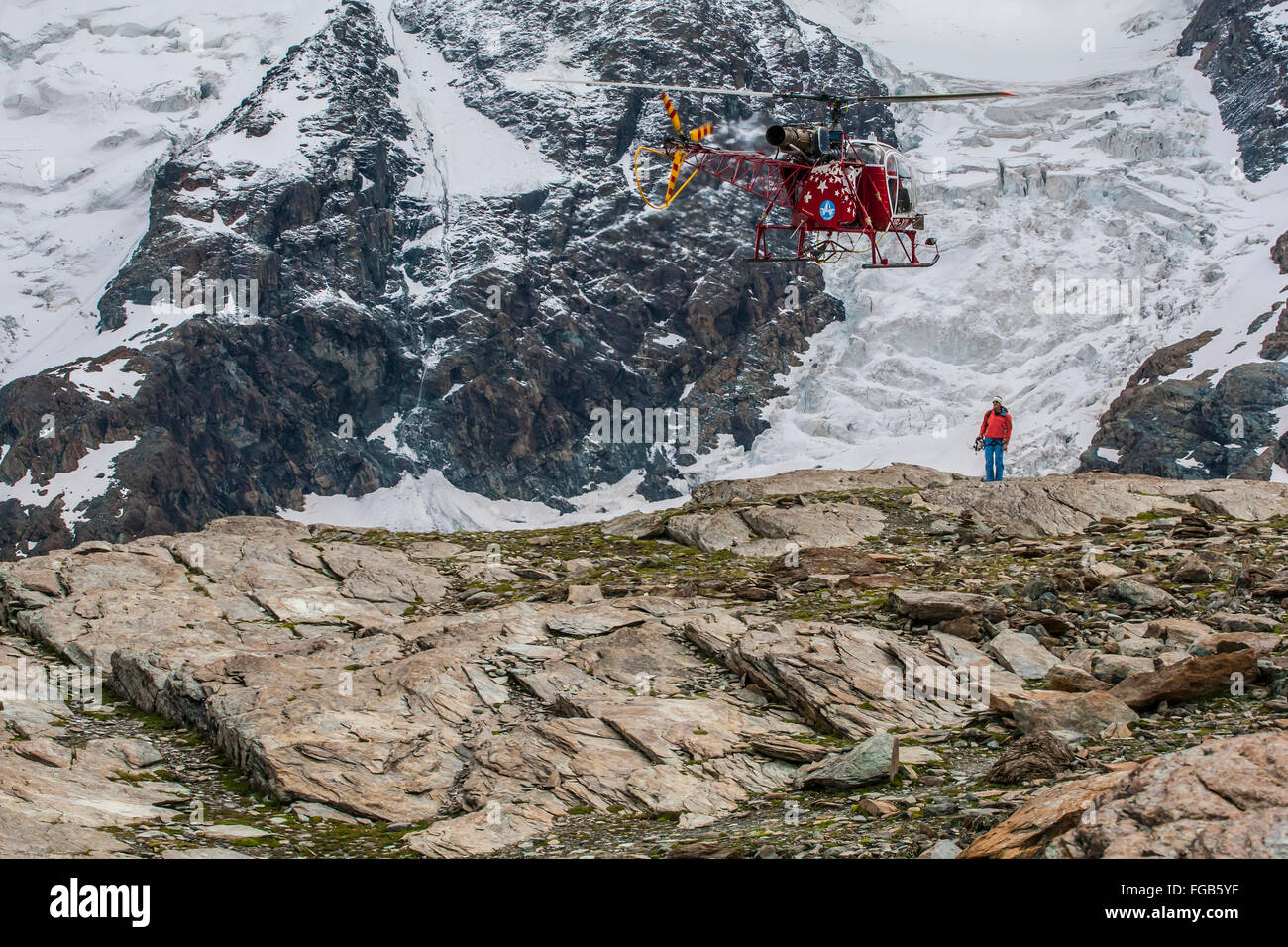 Air Zermatt rescue helicopter picking up a mountain guide to help the ...