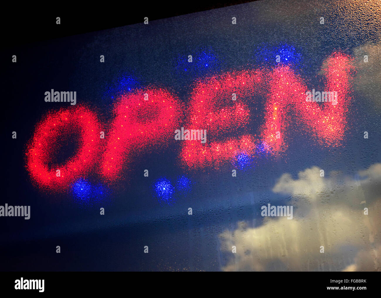 Lit 'Open' restaurant sign in window with condensation forming a ...