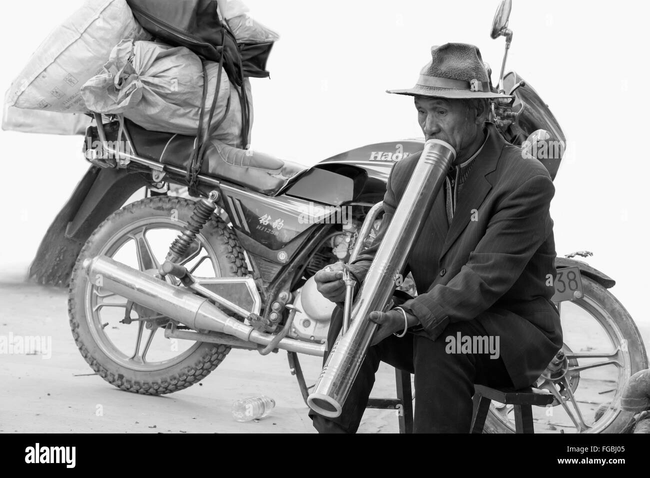 Man, motorcycle and bong, Niujiaozhai Market, Yunnan Province, China ...