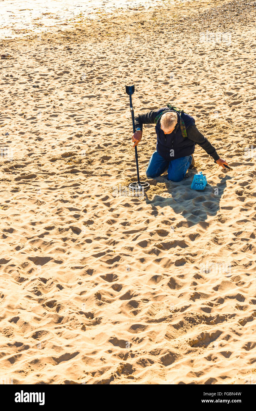 Man using metal detector on sandy at Swanage Stock Photo - Alamy