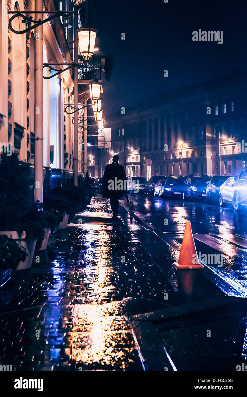 Rear View Of Man Walking On Wet Footpath In City At Night Stock Photo ...