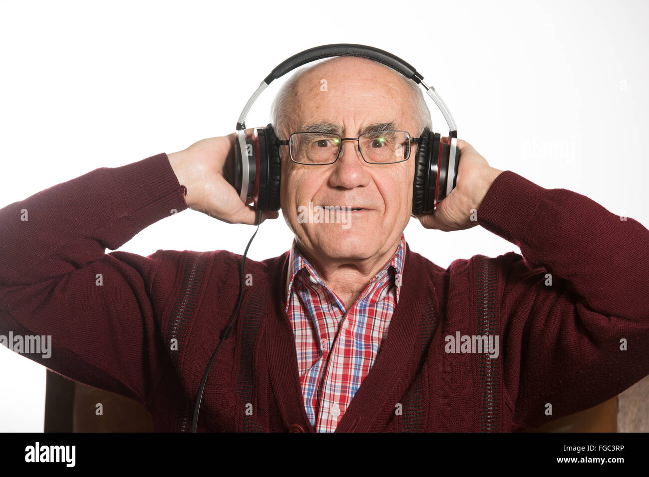 old senior man wearing headphones and listening music wearing red ...