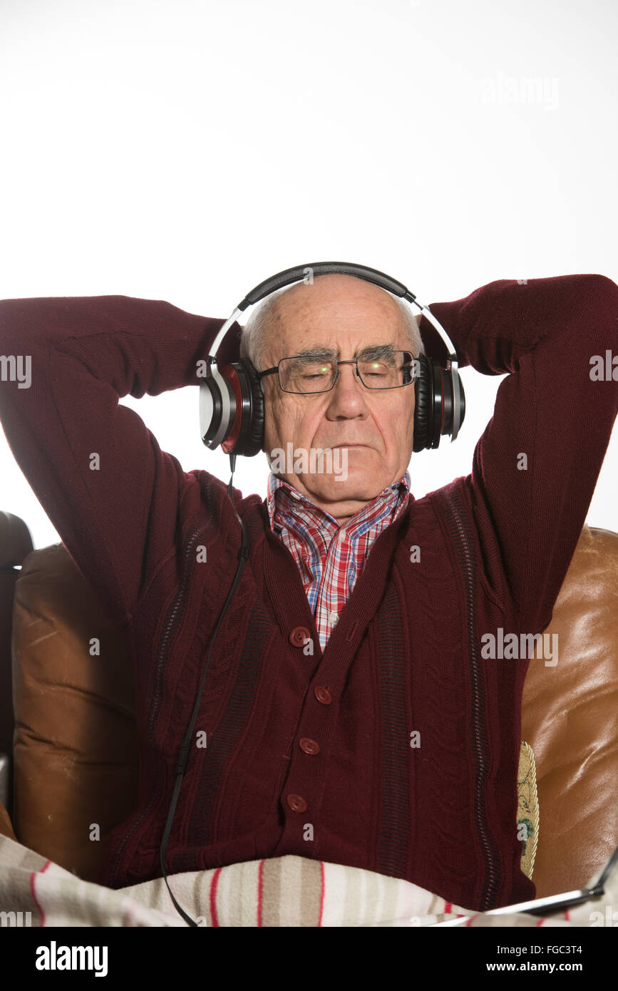 Old Senior Man Wearing Headphones And Listening Music Wearing Red