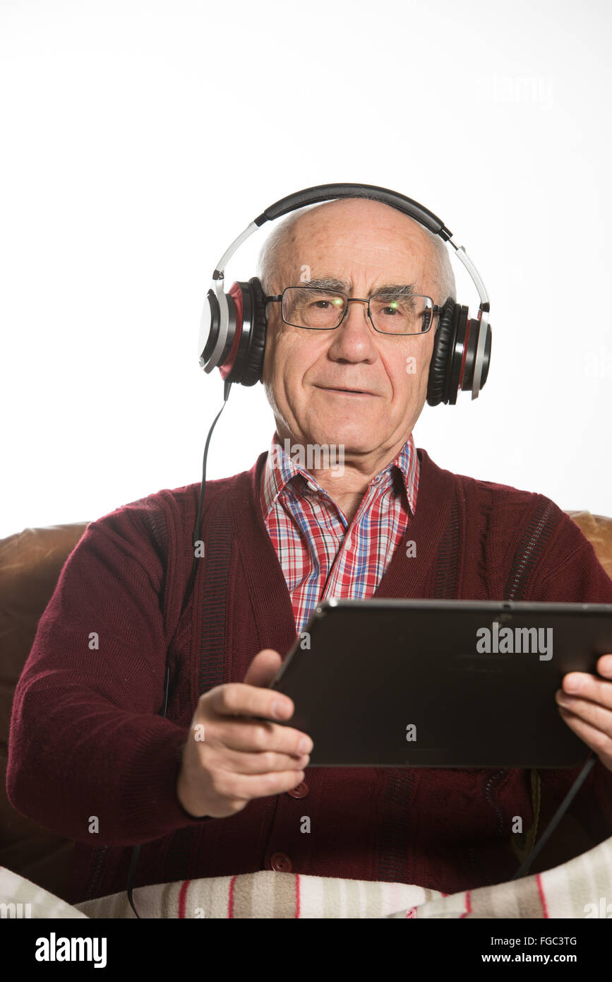 Old Senior Man Wearing Headphones And Listening Music Wearing Red