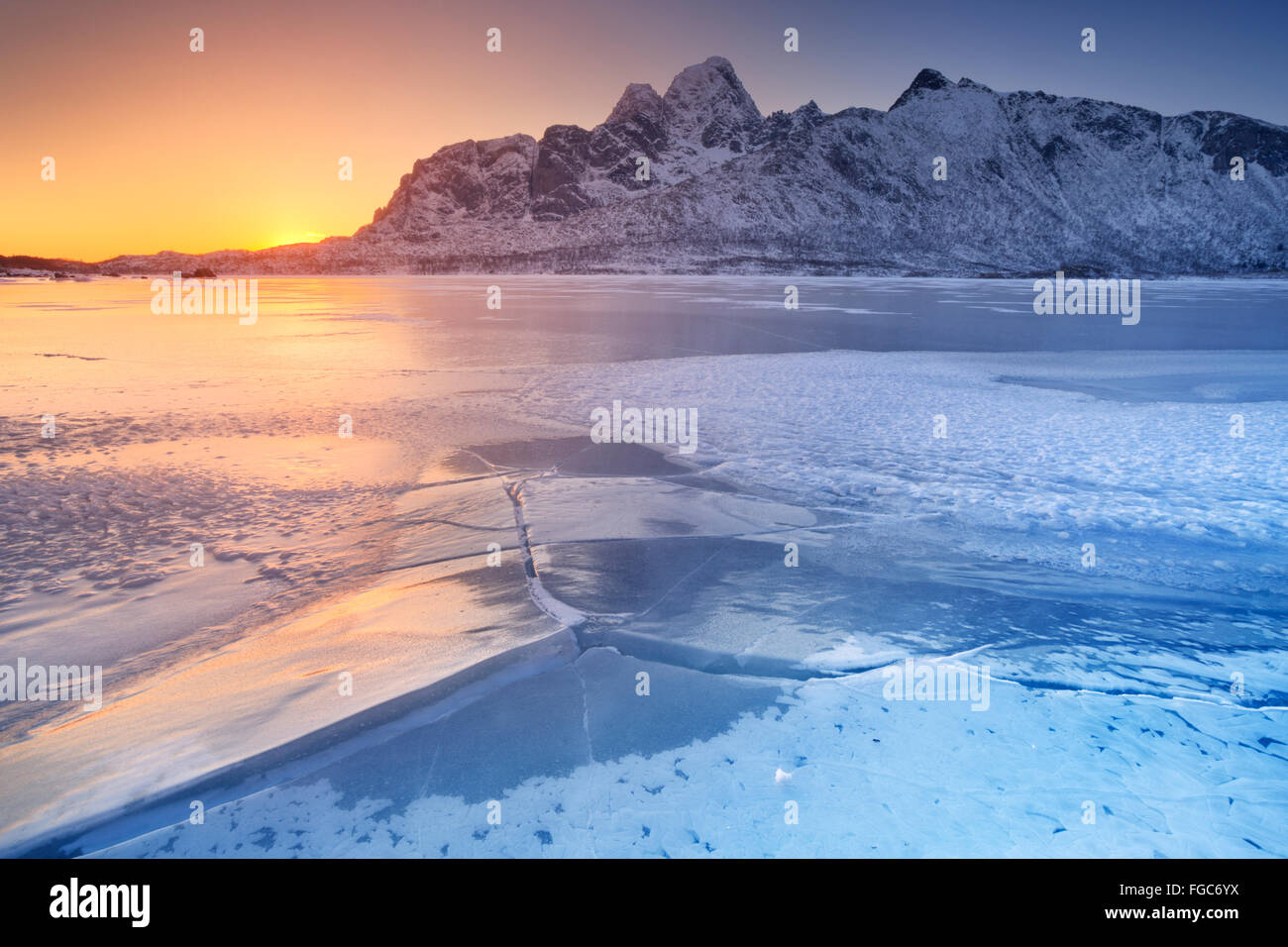 A frozen fjord on the Lofoten in northern Norway with the low midday ...