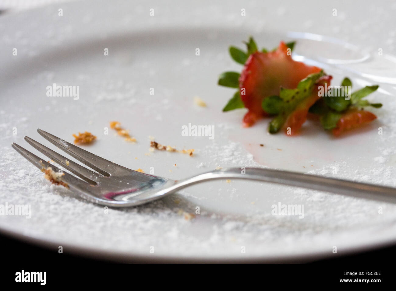 Empty plate with a fork and what remains of a cake Stock Photo - Alamy