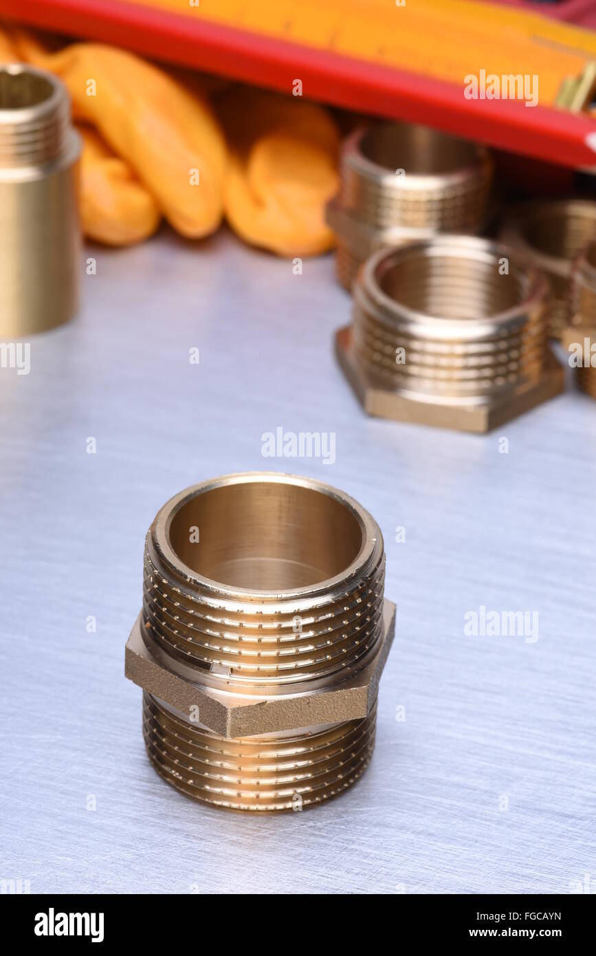 Parts of plumbing fitting with wrench and tools on metal surface Stock ...