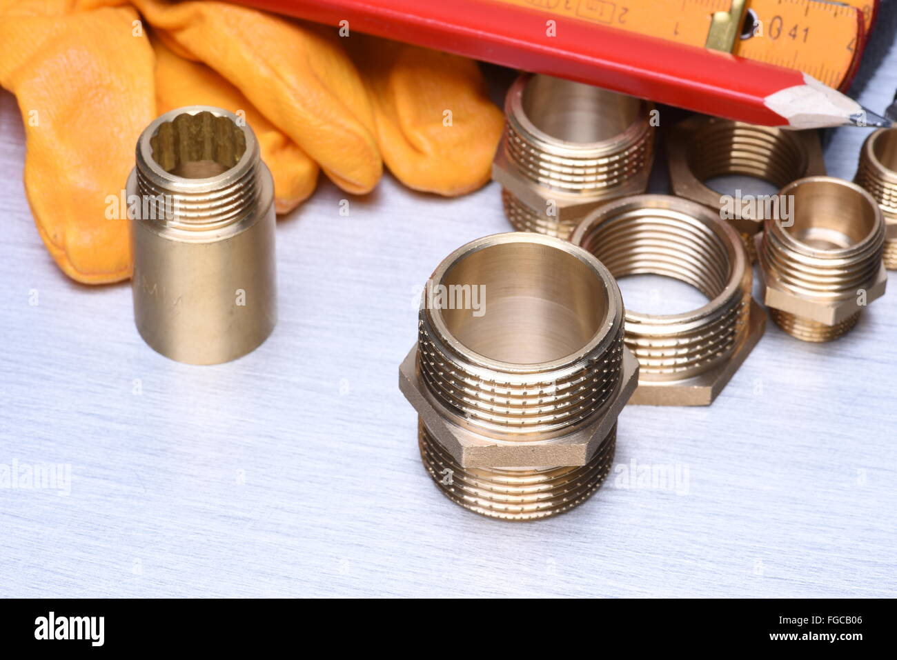 Parts of plumbing fitting with wrench and tools on metal surface Stock ...