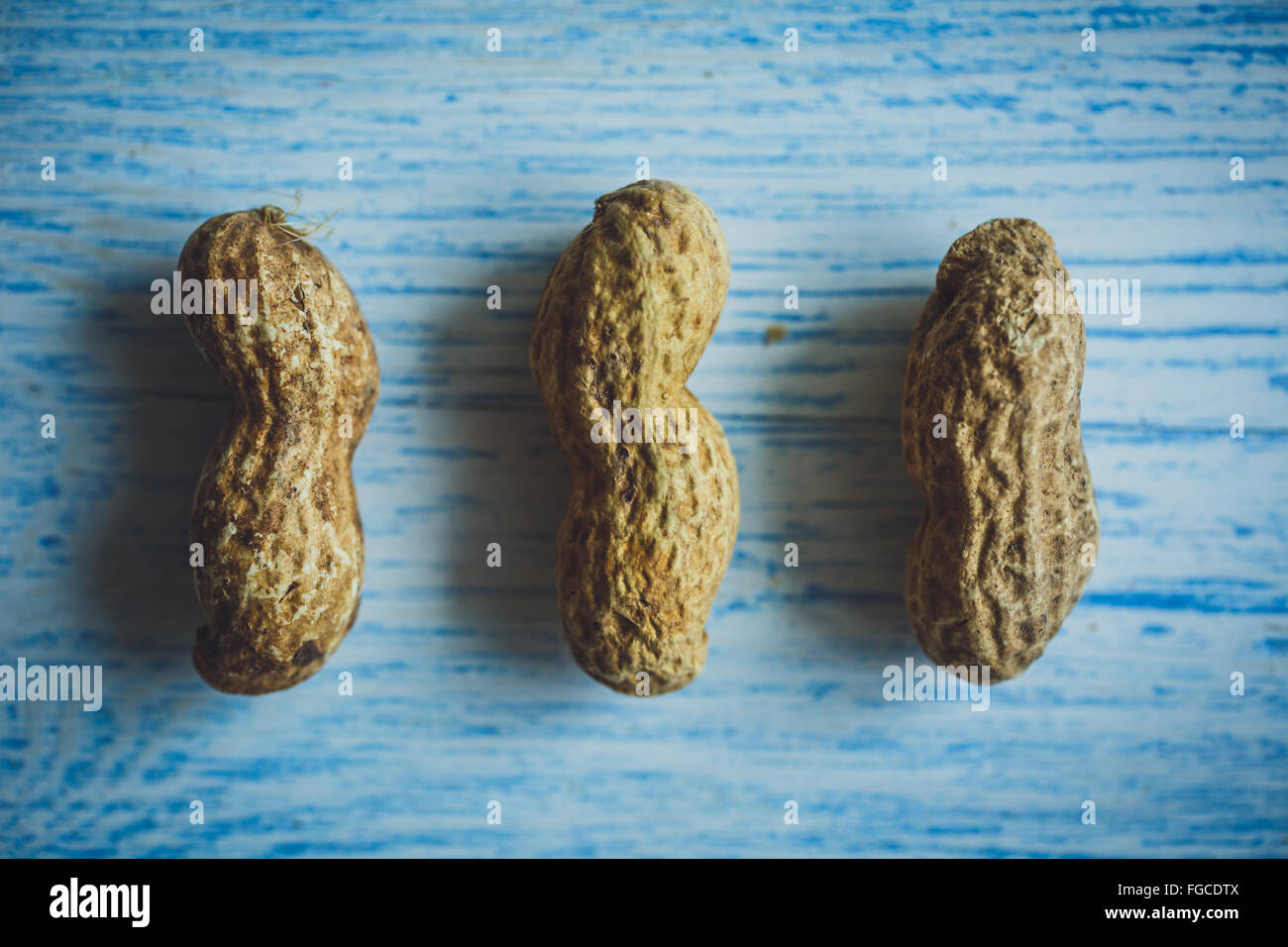 Fresh peanuts in shell on blue desk Stock Photo - Alamy