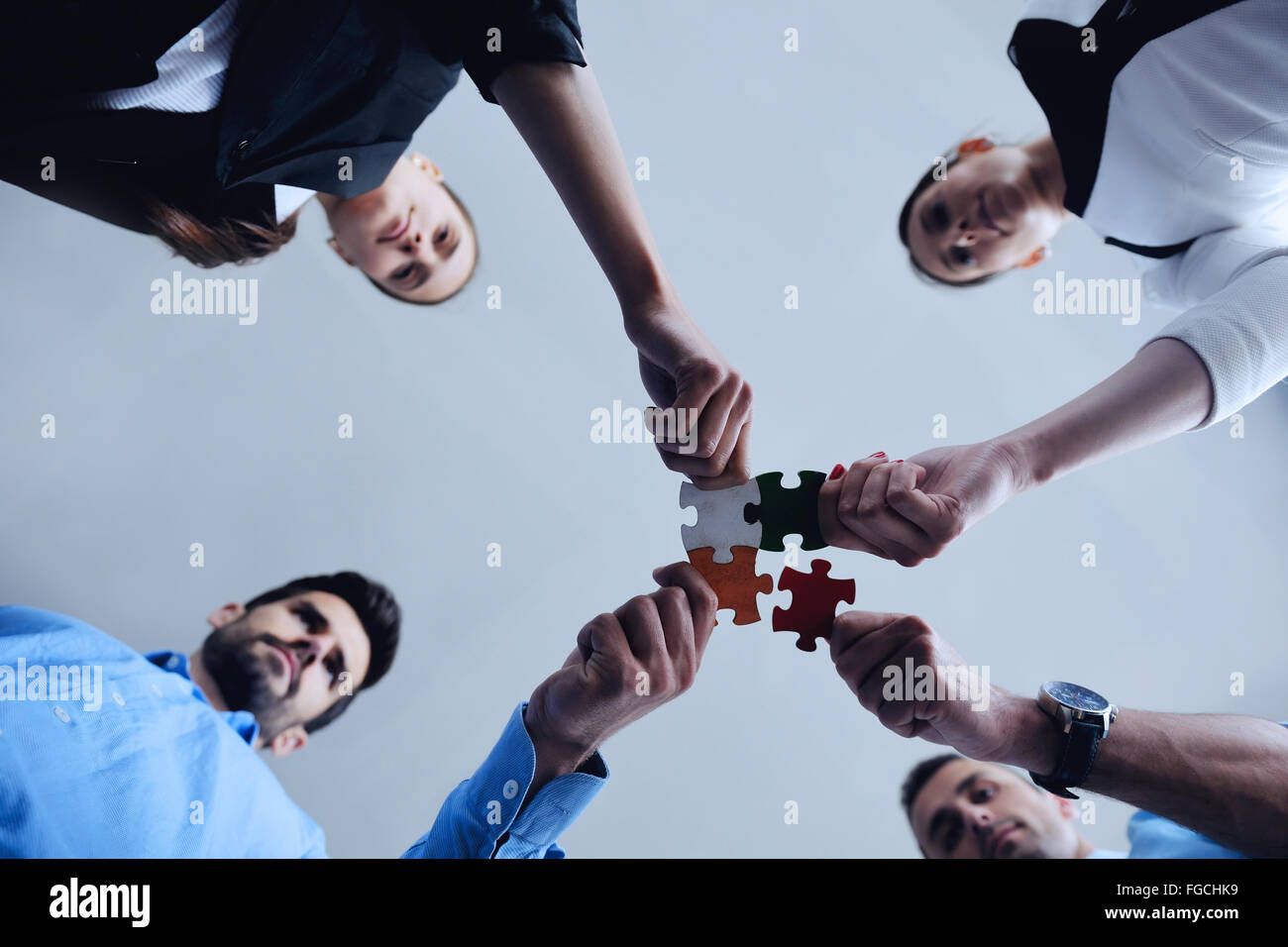Group of business people assembling jigsaw puzzle Stock Photo - Alamy