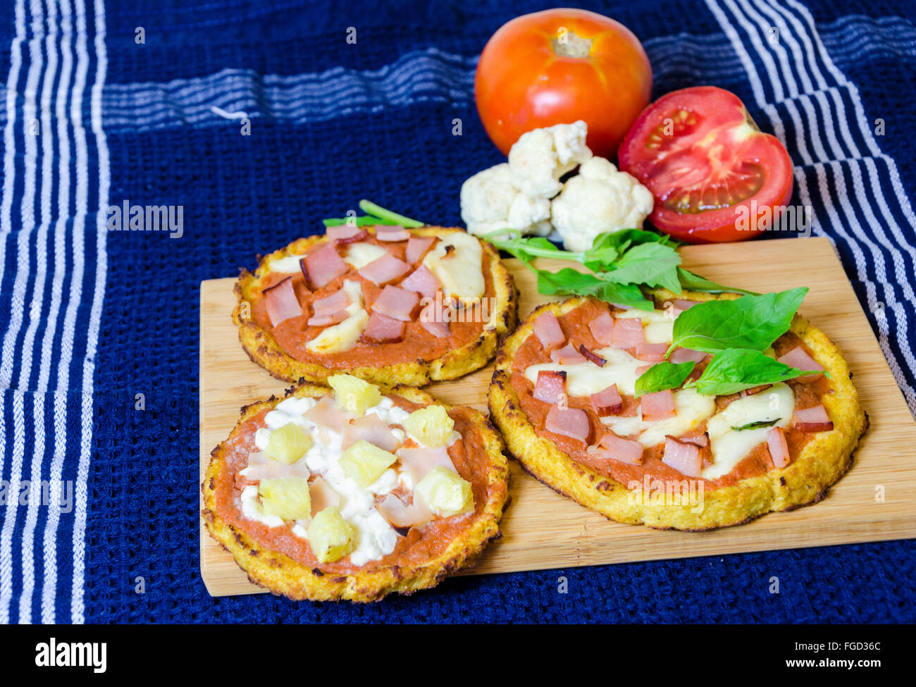 Three small round baked pizzas made of cauliflower crust and topped ...