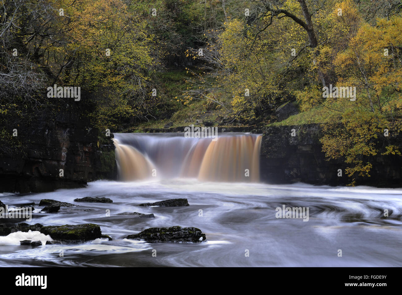 View of waterfall and trees with leaves in autumn colour, Upper Kisdon ...