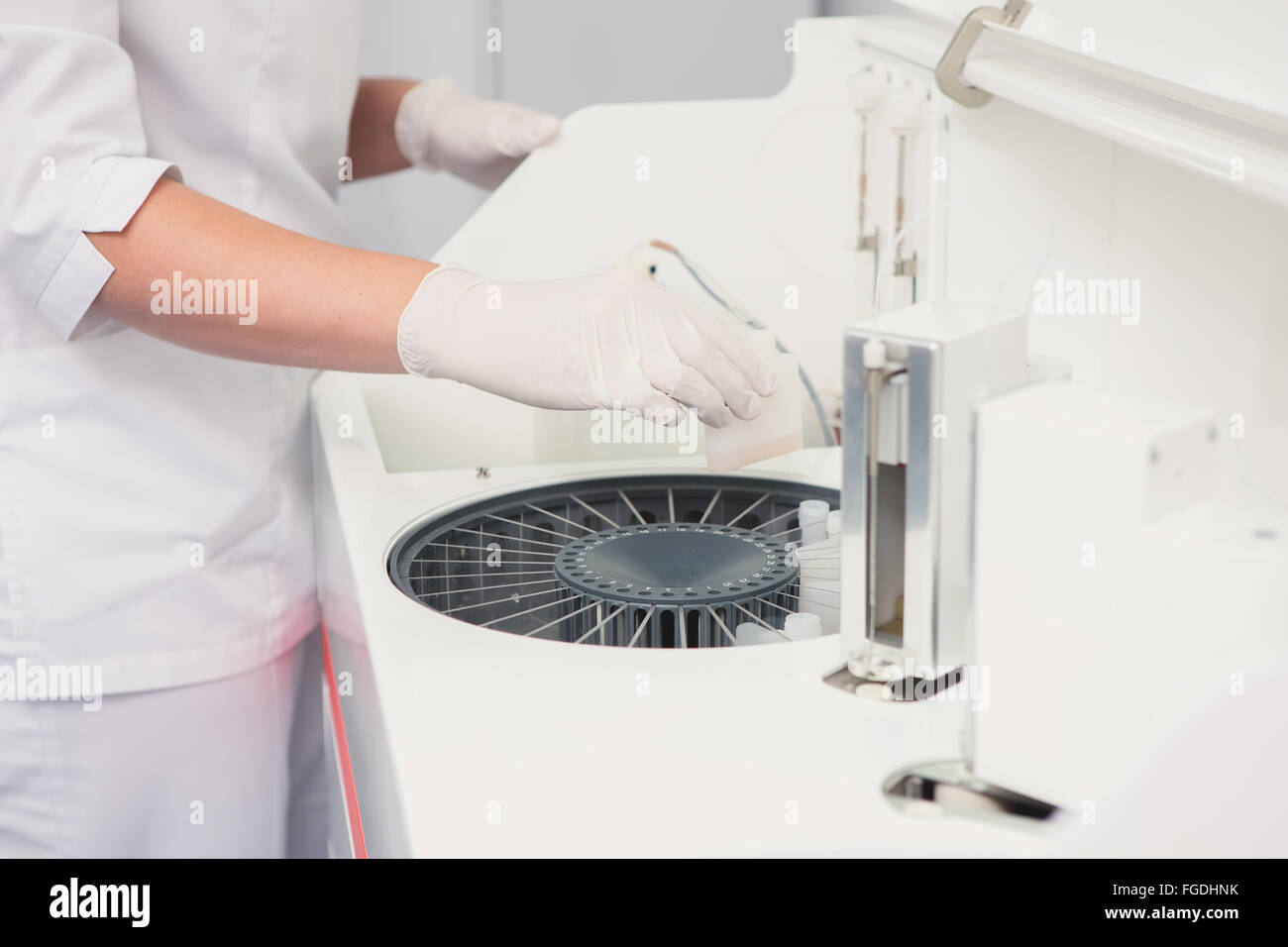 Lab tech loading samples into a chemistry analyzer Stock Photo - Alamy