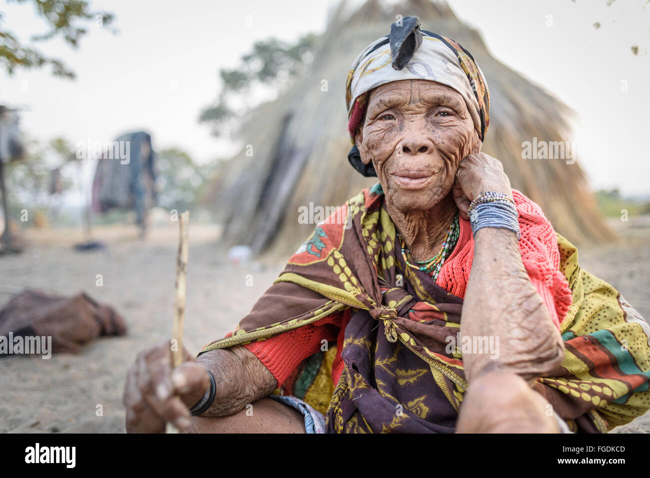 Portrait of an old woman from the bushmen tribe in front of her hut ...