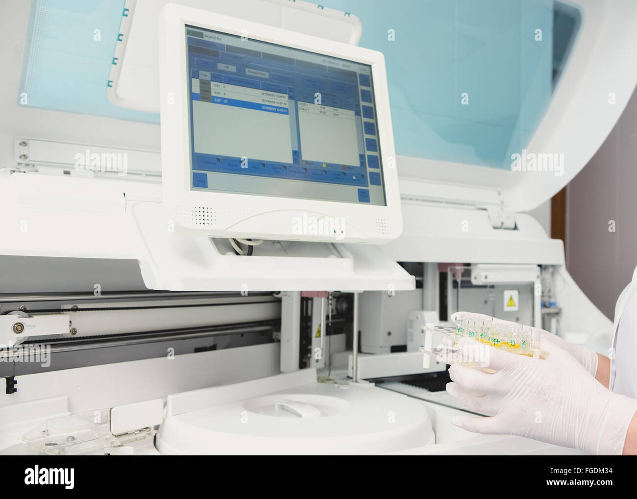 Lab tech loading samples into a chemistry analyzer Stock Photo - Alamy