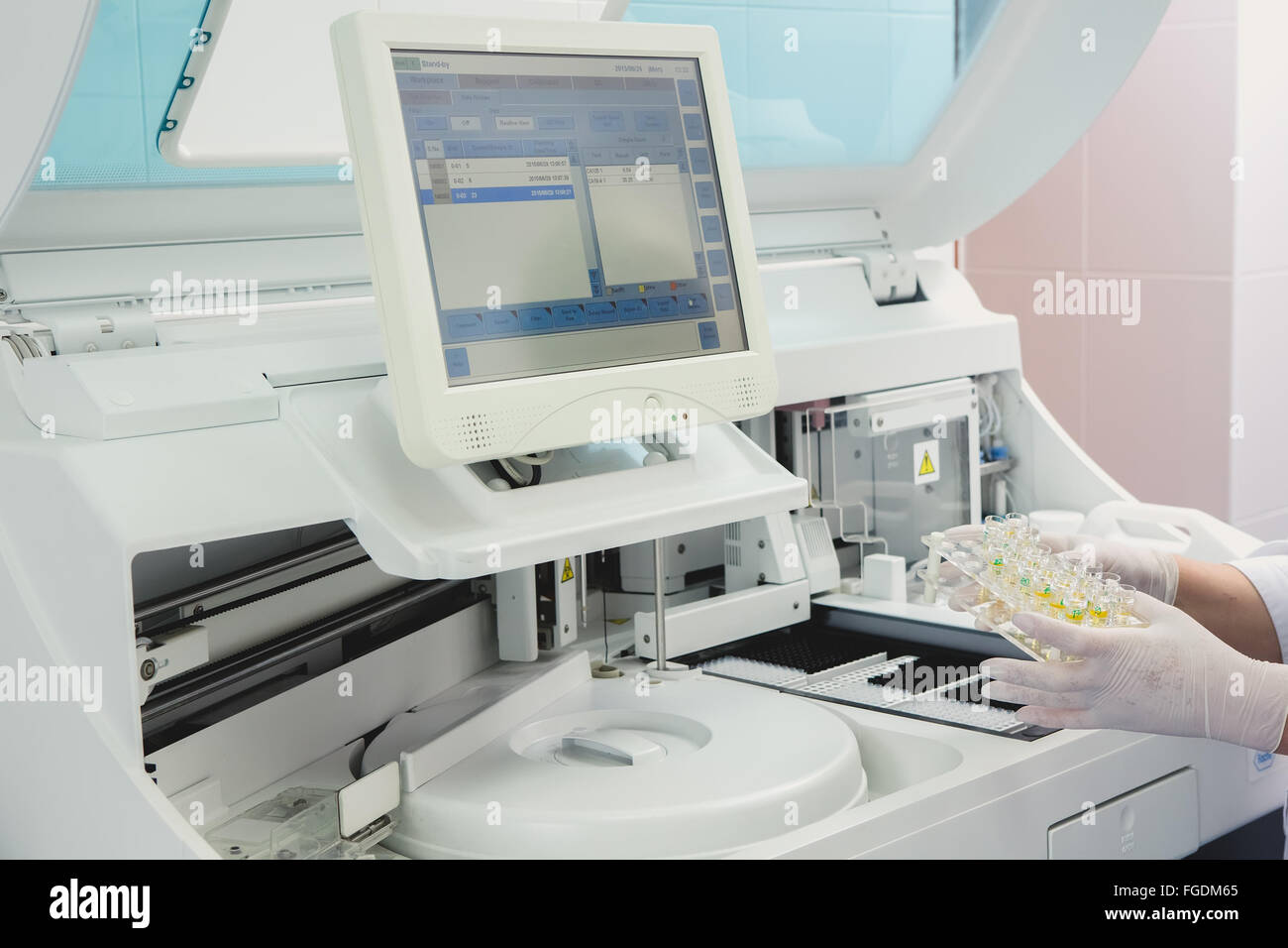 Lab tech loading samples into a chemistry analyzer Stock Photo - Alamy