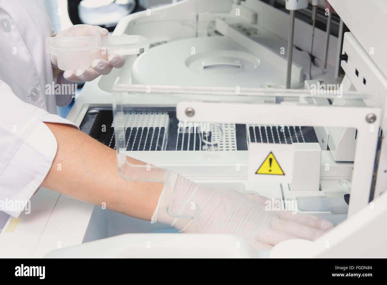 Lab tech loading samples into a chemistry analyzer Stock Photo - Alamy