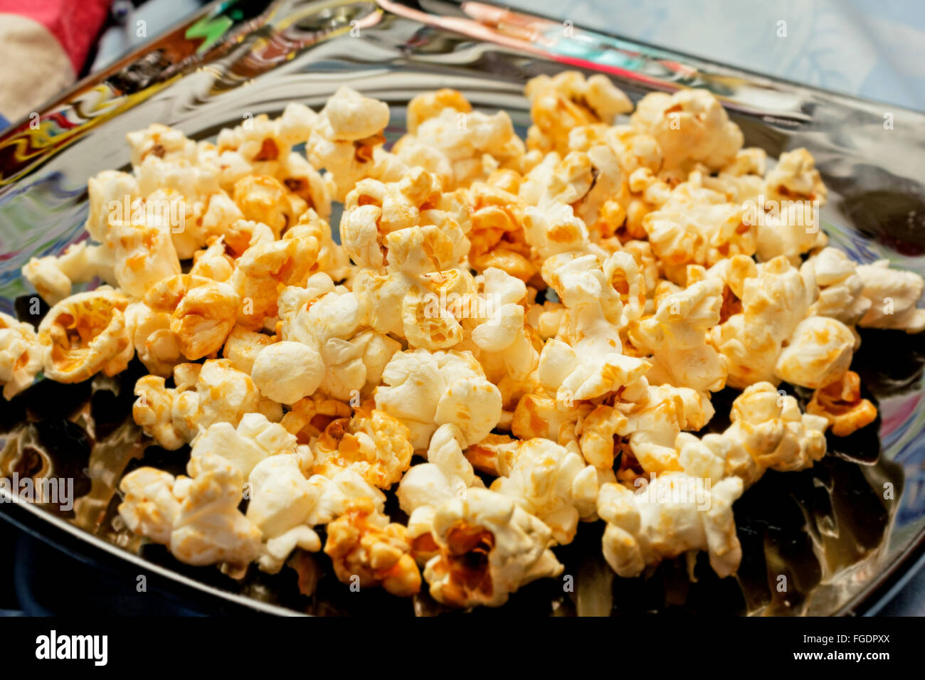 Nice golden popcorn on black plate for eating Stock Photo - Alamy