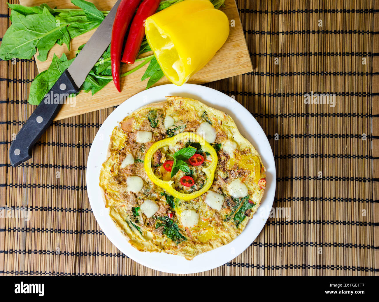Top view of a spinach, chili, mint and pepper omelette in a dish over ...