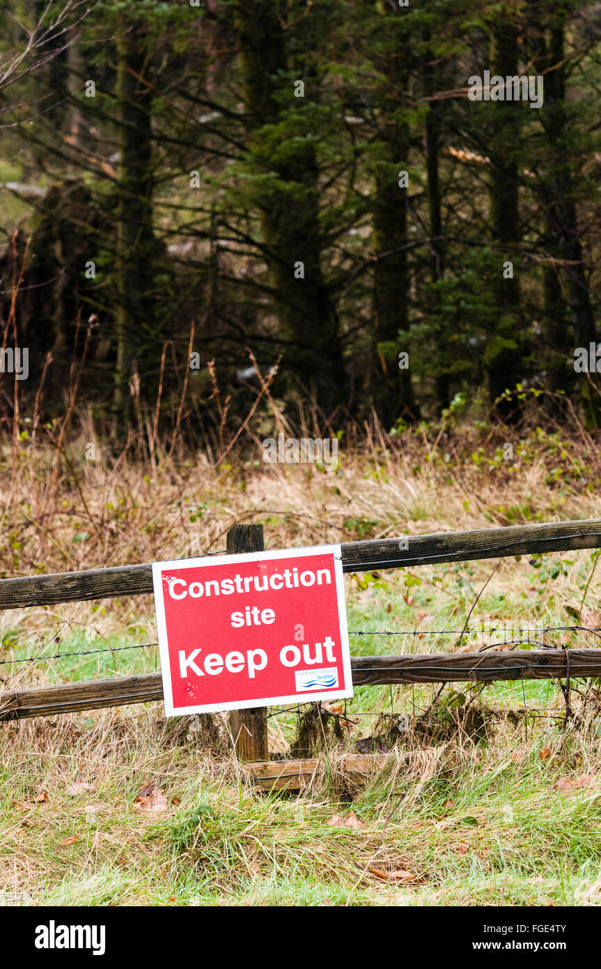 Construction sign on the fence of a forest, warning public to keep out ...