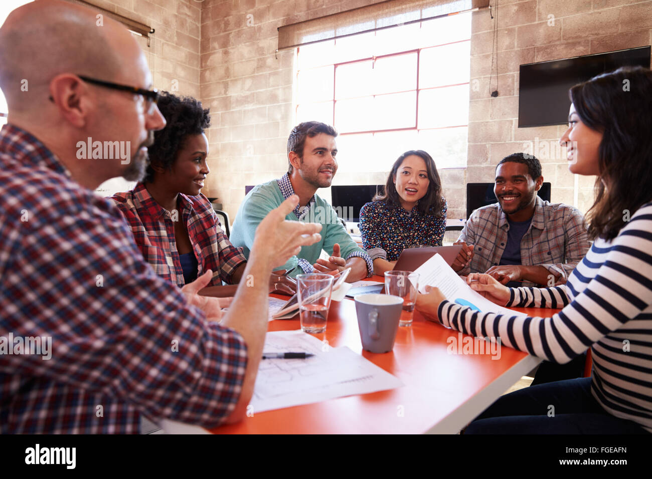 Group Of Designers Having Meeting Around Table In Office Stock Photo ...