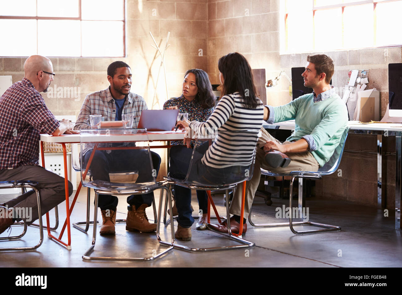 Group Of Designers Having Meeting Around Table In Office Stock Photo ...