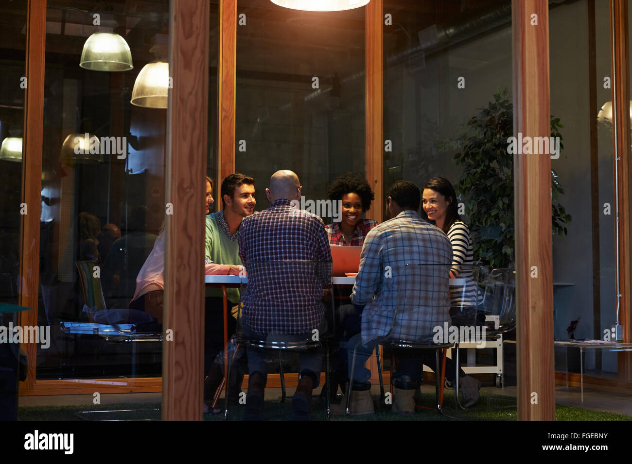 Late Night Meeting Around Table In Design Office Stock Photo - Alamy