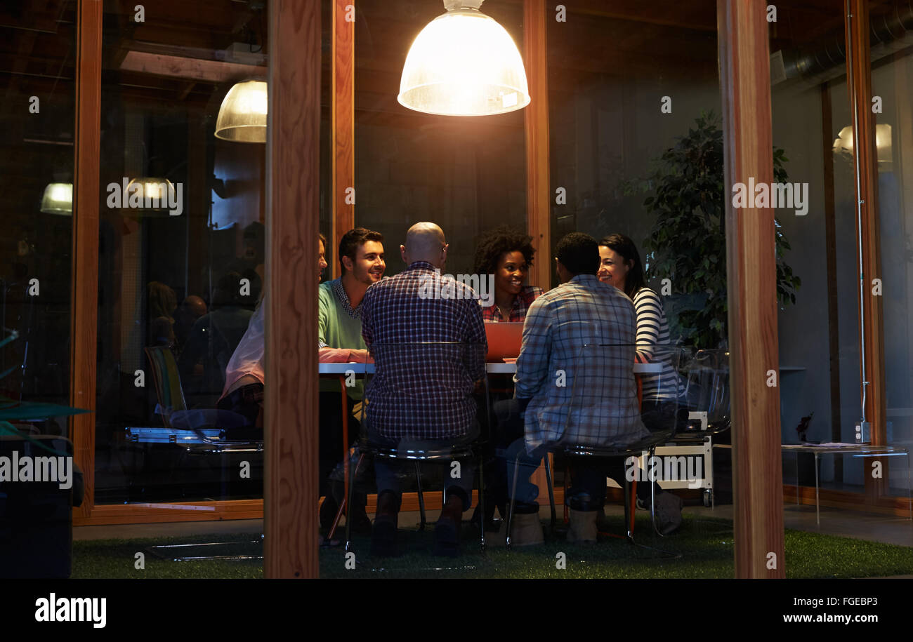 Late Night Meeting Around Table In Design Office Stock Photo - Alamy