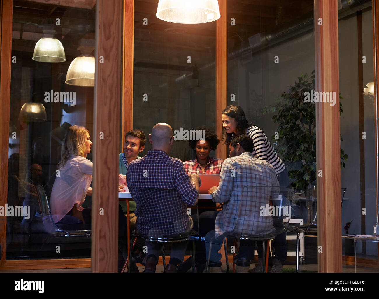 Late Night Meeting Around Table In Design Office Stock Photo - Alamy