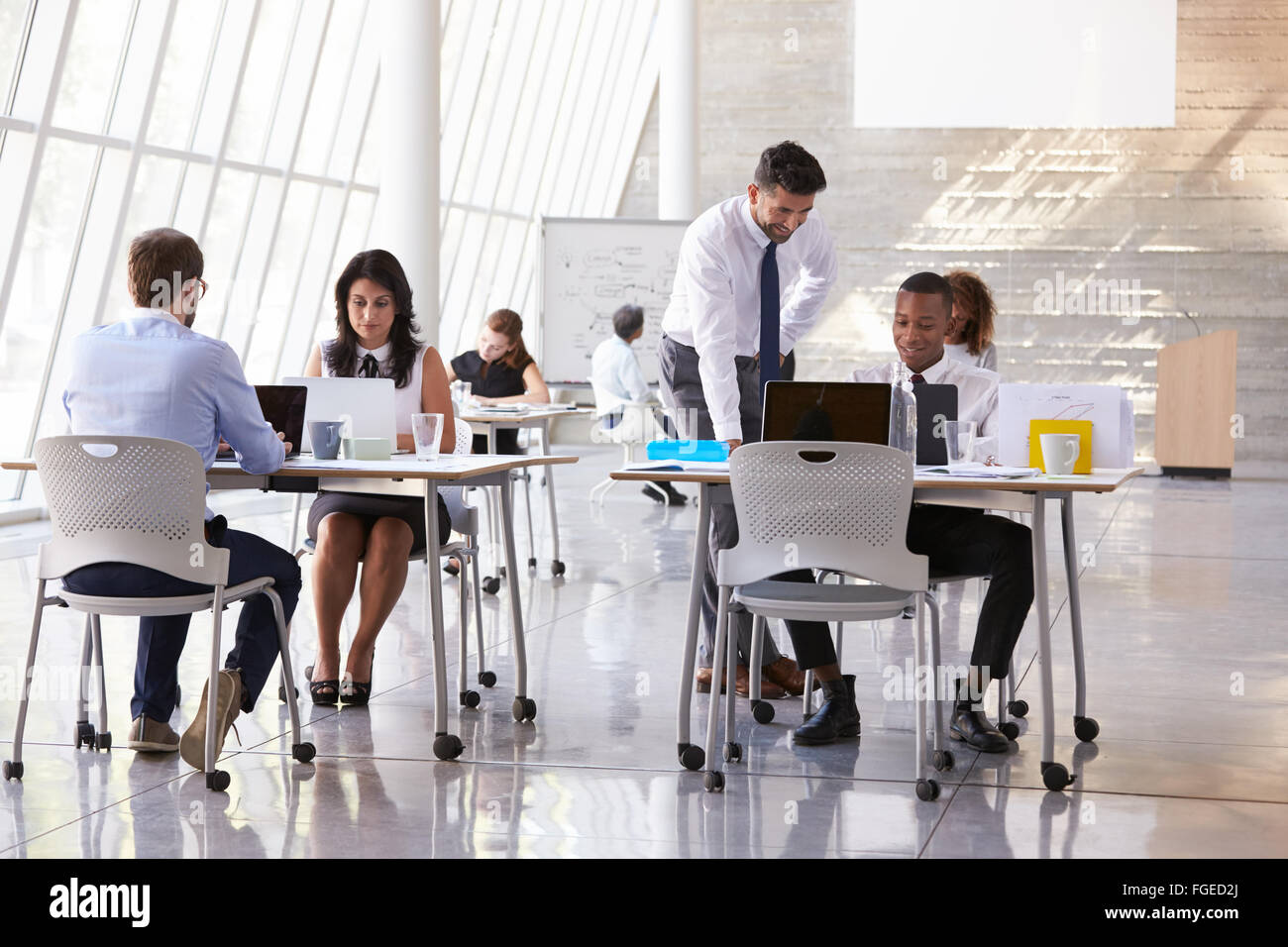 Manager helping staff in busy hi-res stock photography and images - Alamy