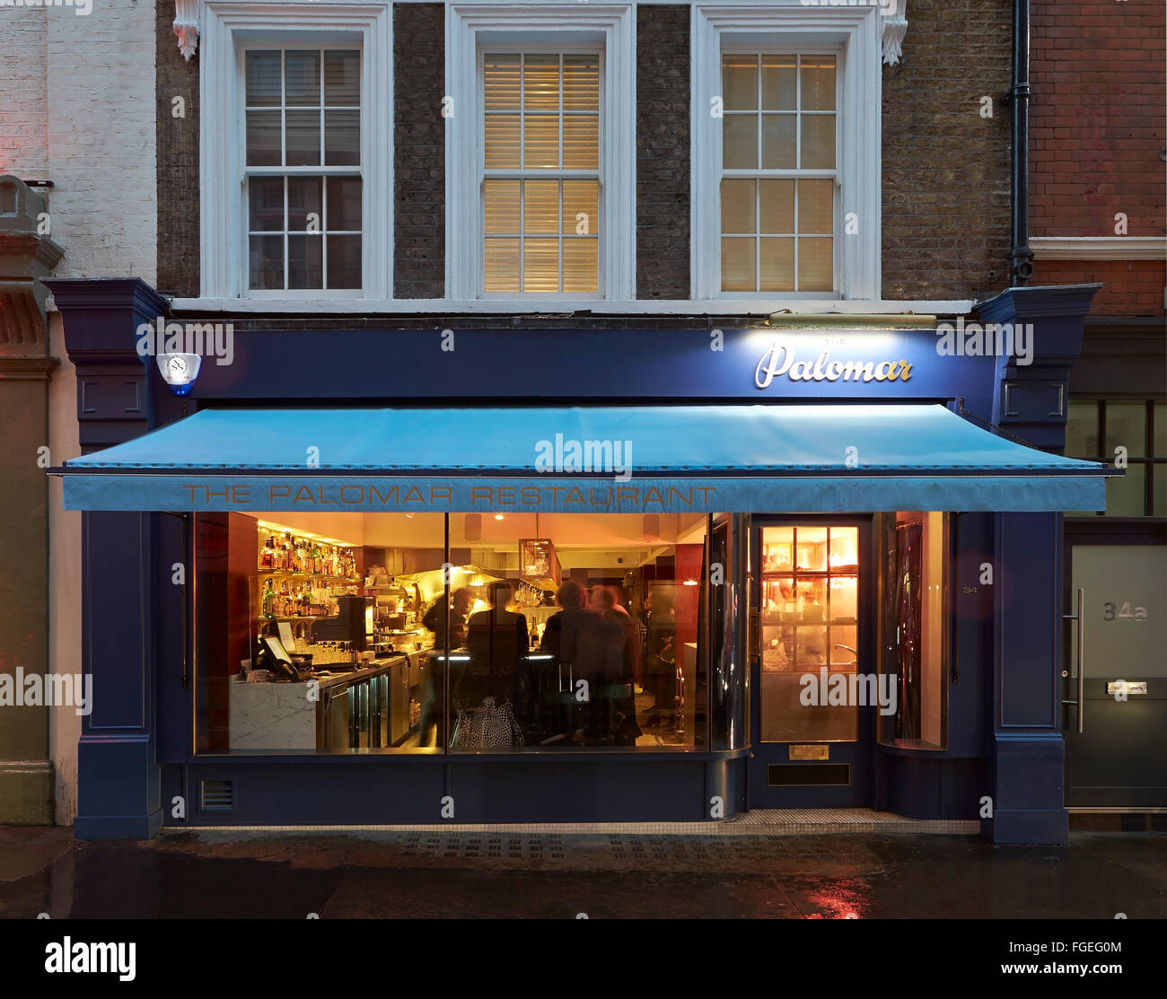Building facade with awning and illuminated interior. The Palomar ...