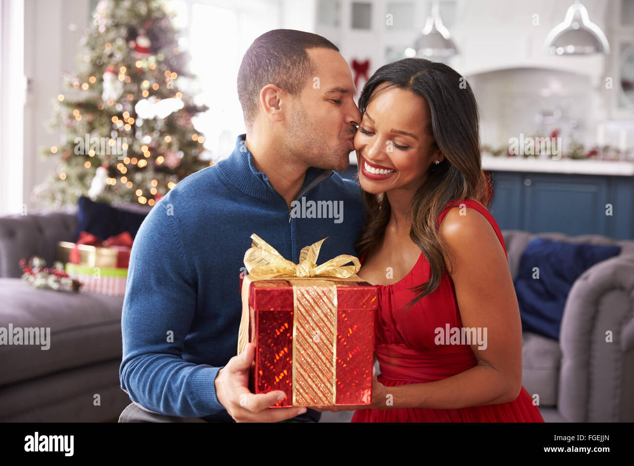 Romantic Couple Exchanging Christmas Gifts At Home Stock Photo - Alamy