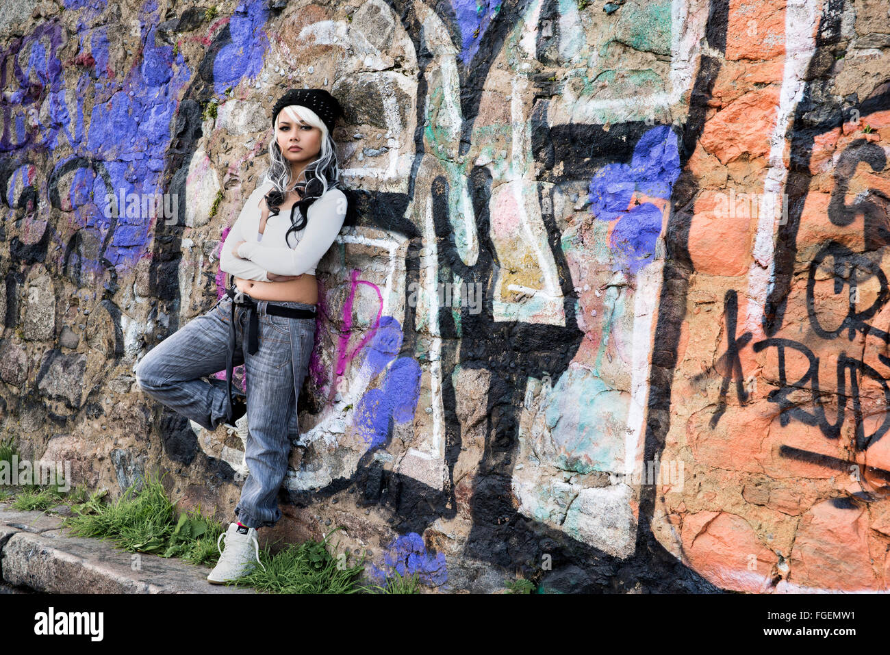 female model in urban location graffiti walls wearing jeans and white ...