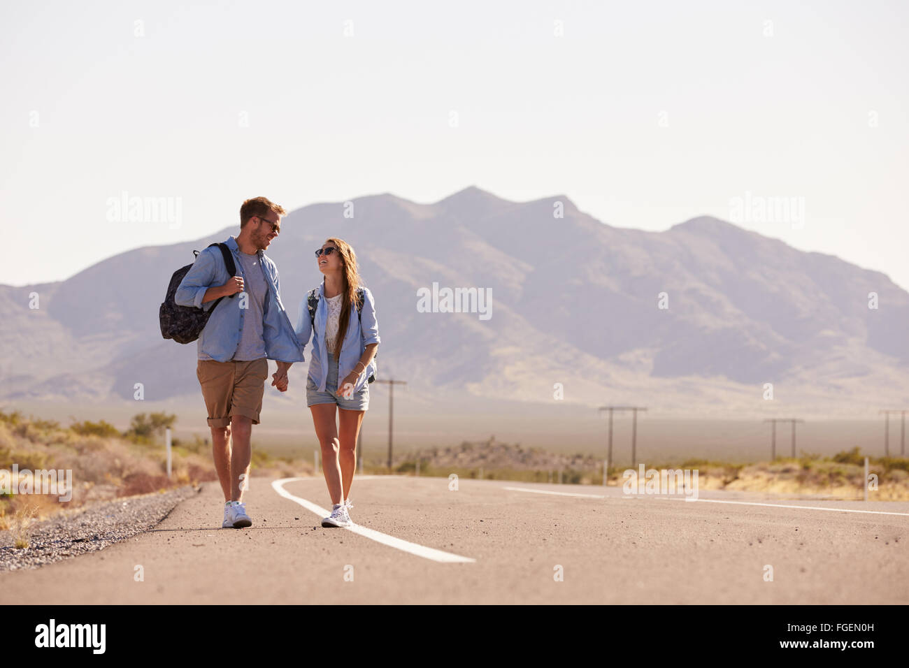 Couple On Vacation Hitchhiking Along Road Stock Photo - Alamy
