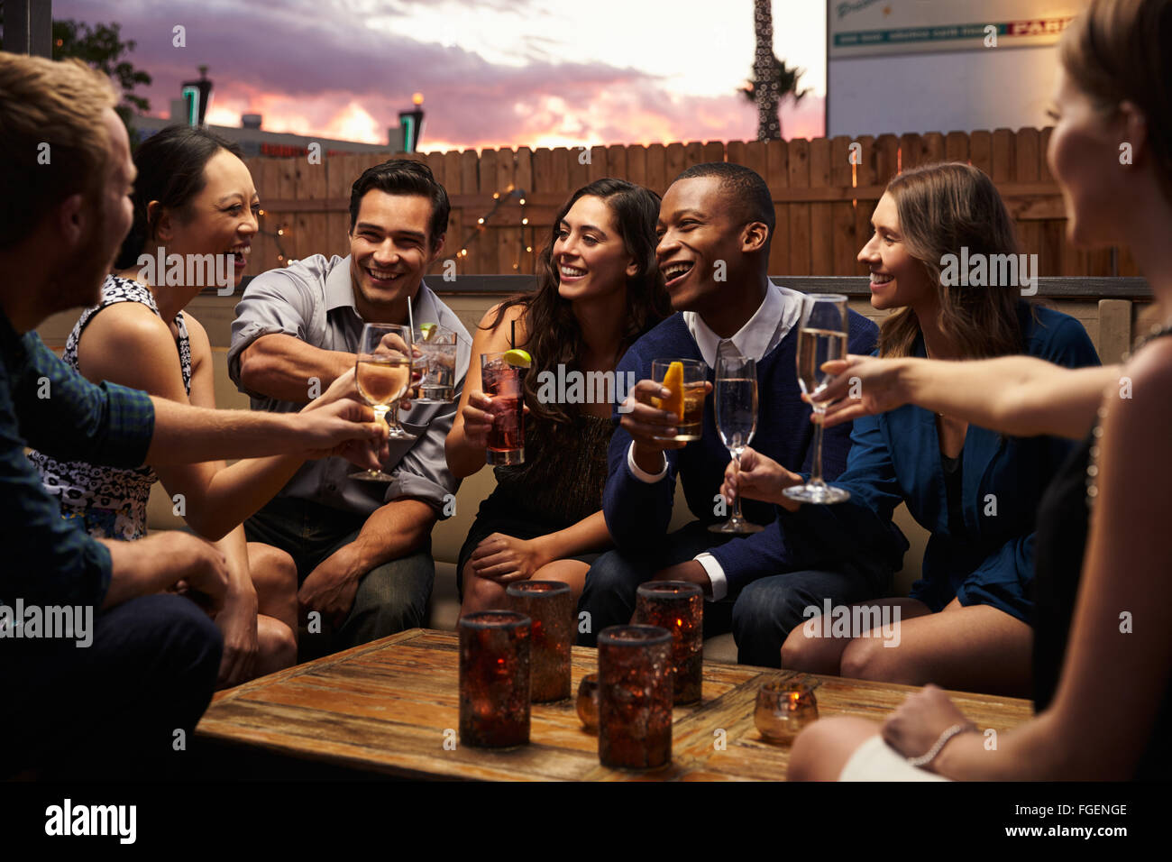 Group Of Friends Enjoying Night Out At Rooftop Bar Stock Photo - Alamy