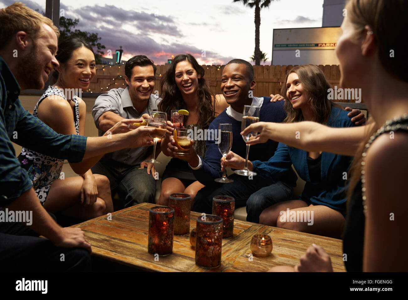 Group Of Friends Enjoying Night Out At Rooftop Bar Stock Photo - Alamy