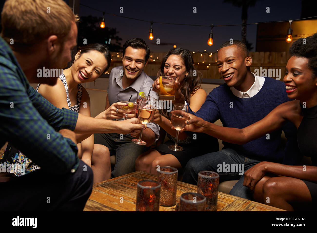 Group Of Friends Enjoying Night Out At Rooftop Bar Stock Photo - Alamy