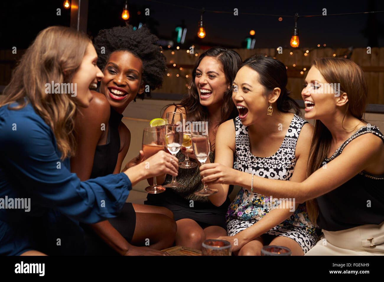 Group Of Female Friends Enjoying Night Out At Rooftop Bar Stock Photo ...