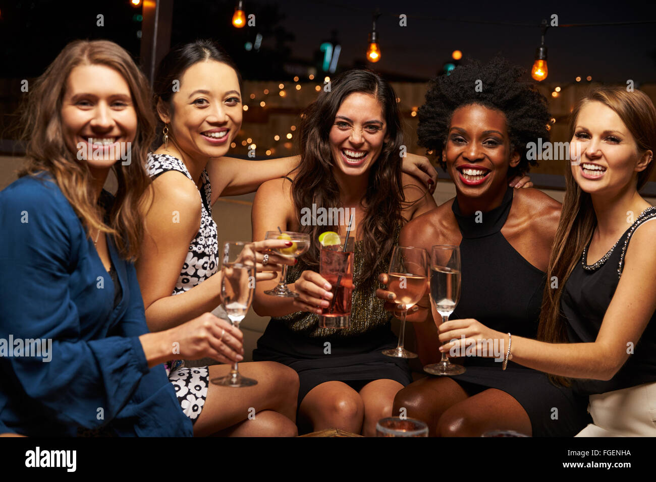 Portrait Of Female Friends Enjoying Night Out At Rooftop Bar Stock ...