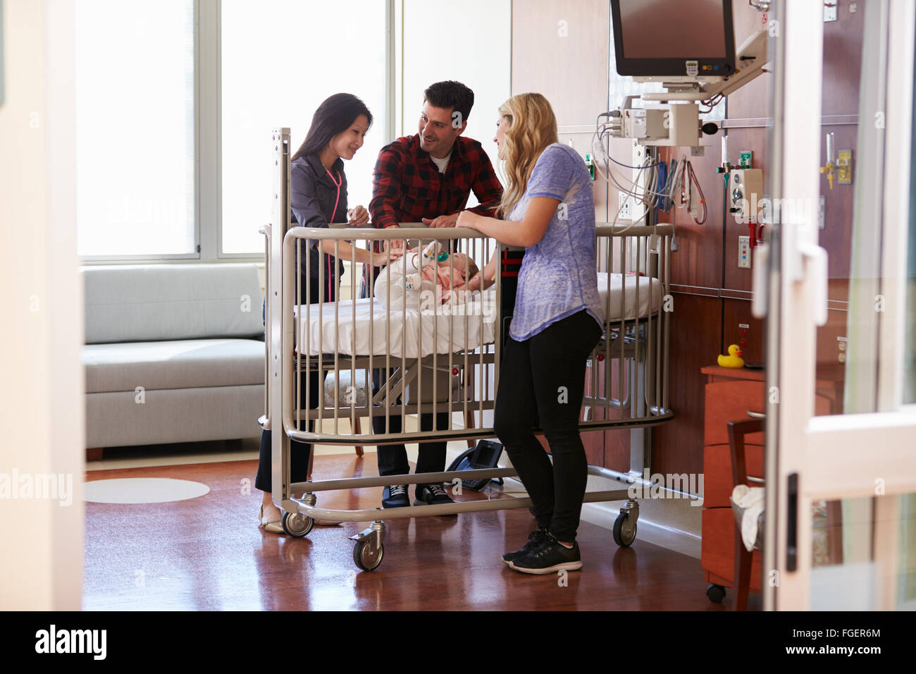 Pediatrician Visiting Parents And Child In Hospital Bed Stock Photo - Alamy