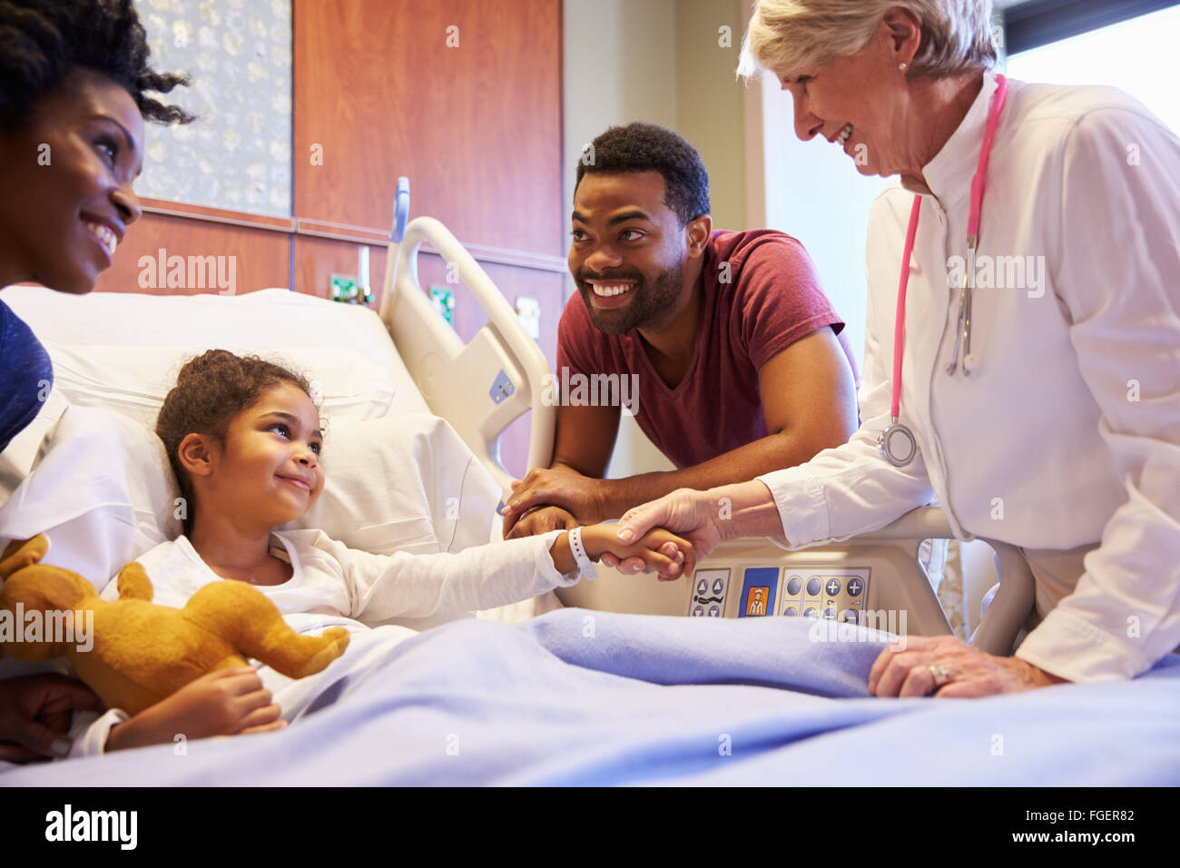 Pediatrician Visiting Parents And Child In Hospital Bed Stock Photo - Alamy