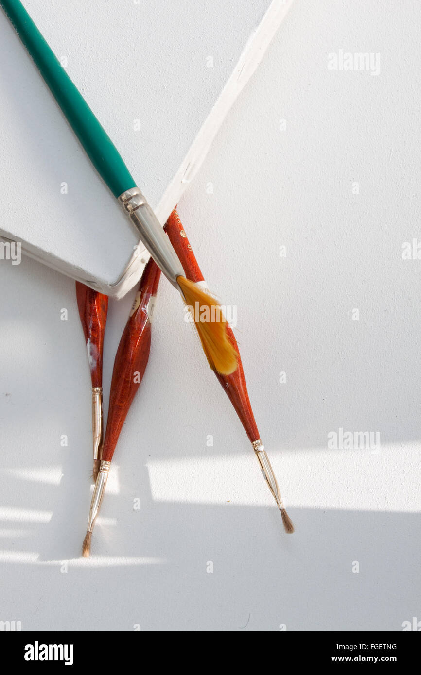 Artists brushes and paint container Stock Photo - Alamy
