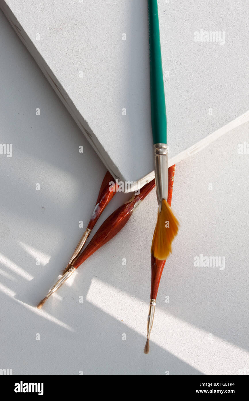 Artists brushes and paint container Stock Photo - Alamy